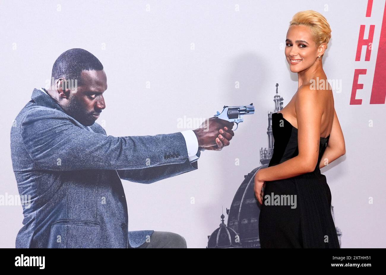 Nathalie Emmanuel, a cast member in "The Killer," poses against key art ...