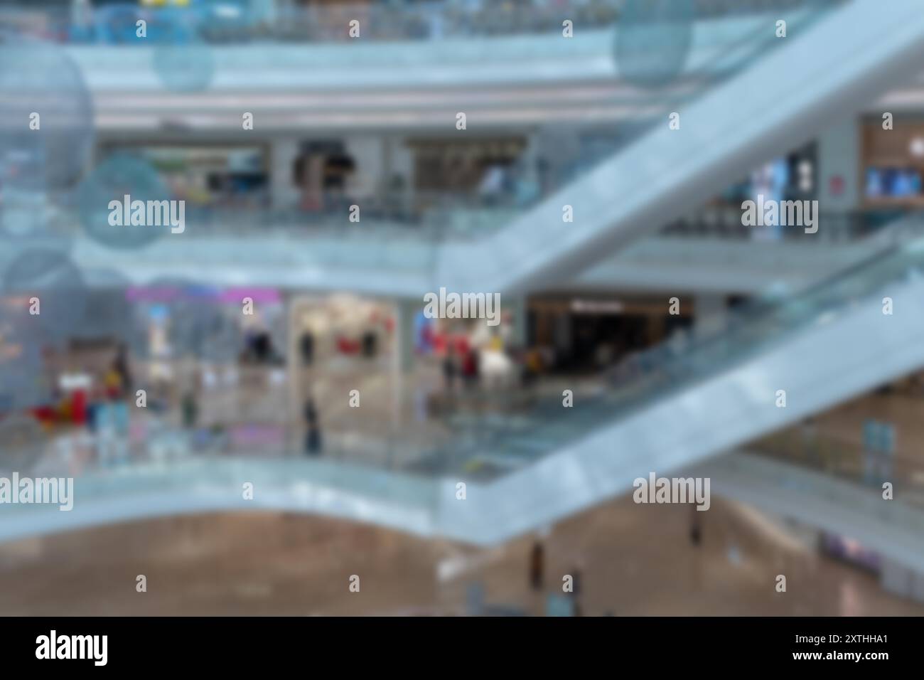 Blurred view of a modern shopping mall with escalators and white ...