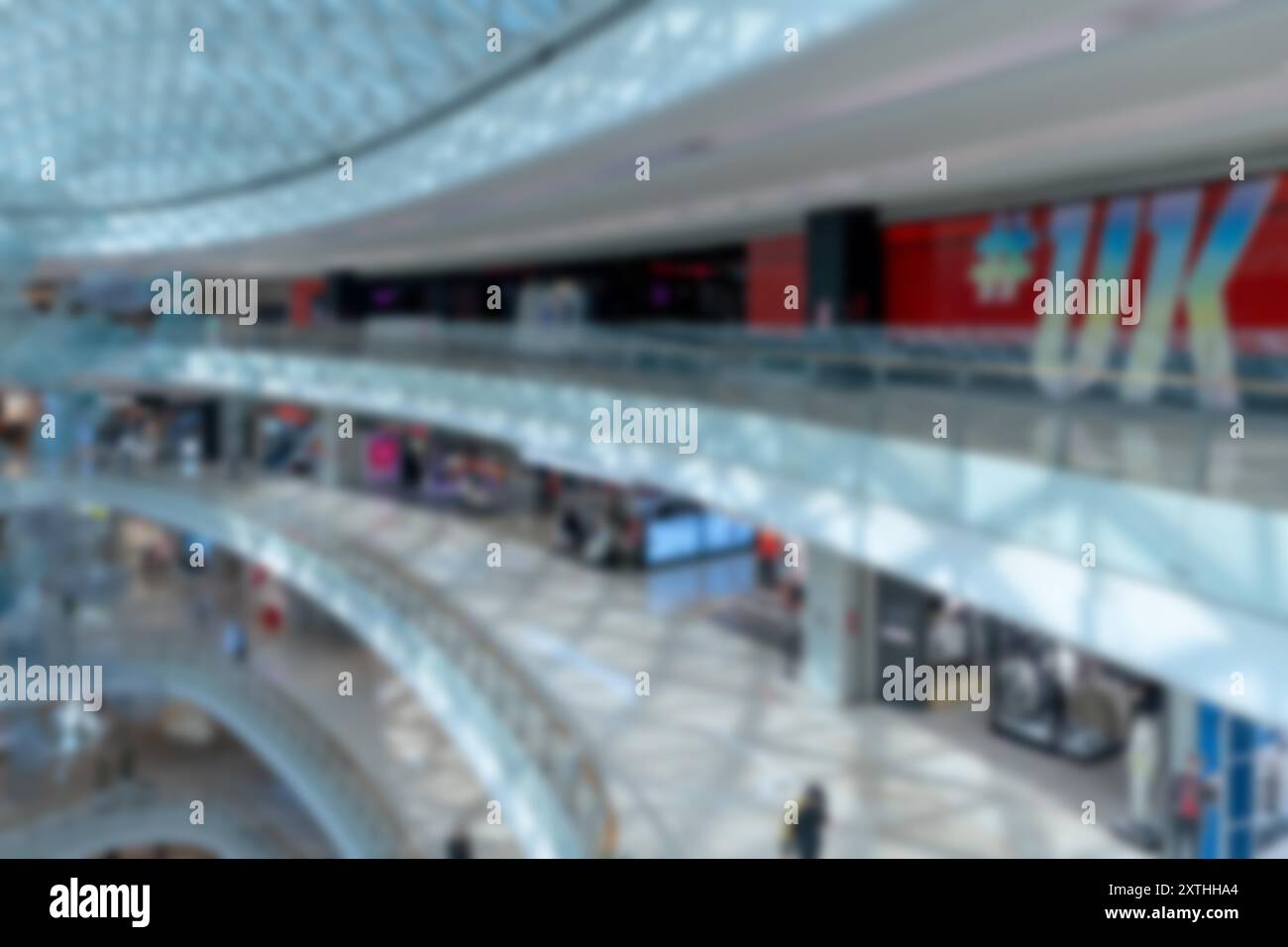 Blurred view of a large shopping mall interior with a curved ceiling ...