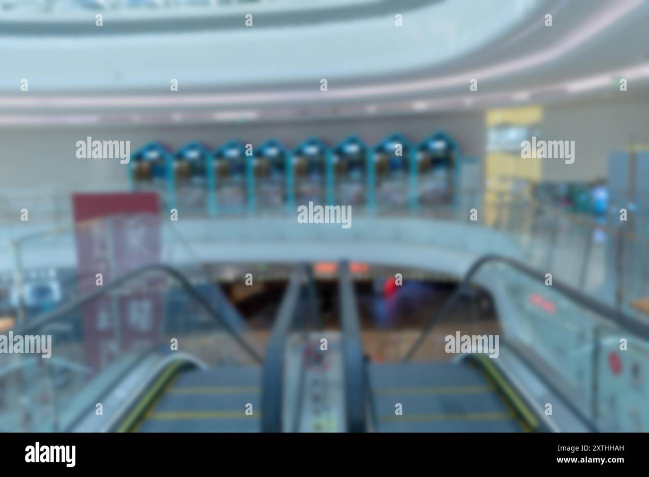 A blurry image of two escalators in a shopping mall in Shenzhen, China. The image is composed of ...