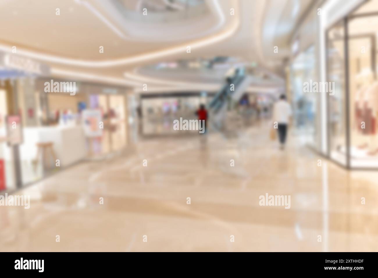 A blurred view of a shopping mall with a moving walkway. The mall ...
