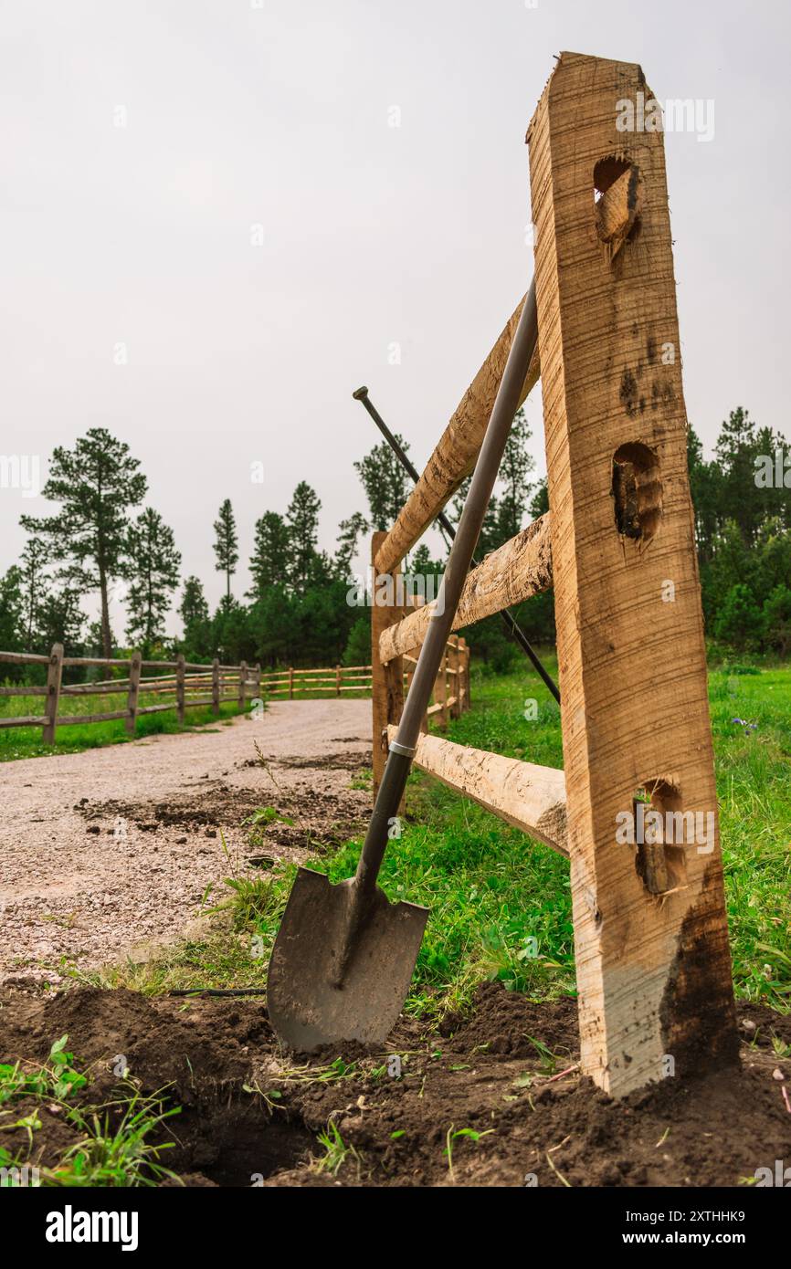Shovel leaning against a wooden, split-rail fence. Fence and road ...