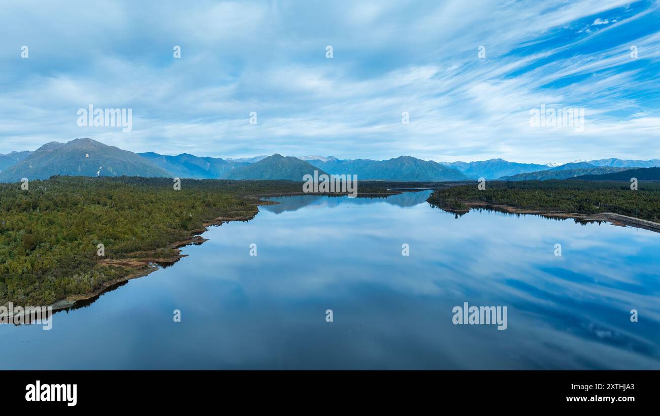 Remote Kapitea Reservoir reflections surrounded by mountain ranges ...