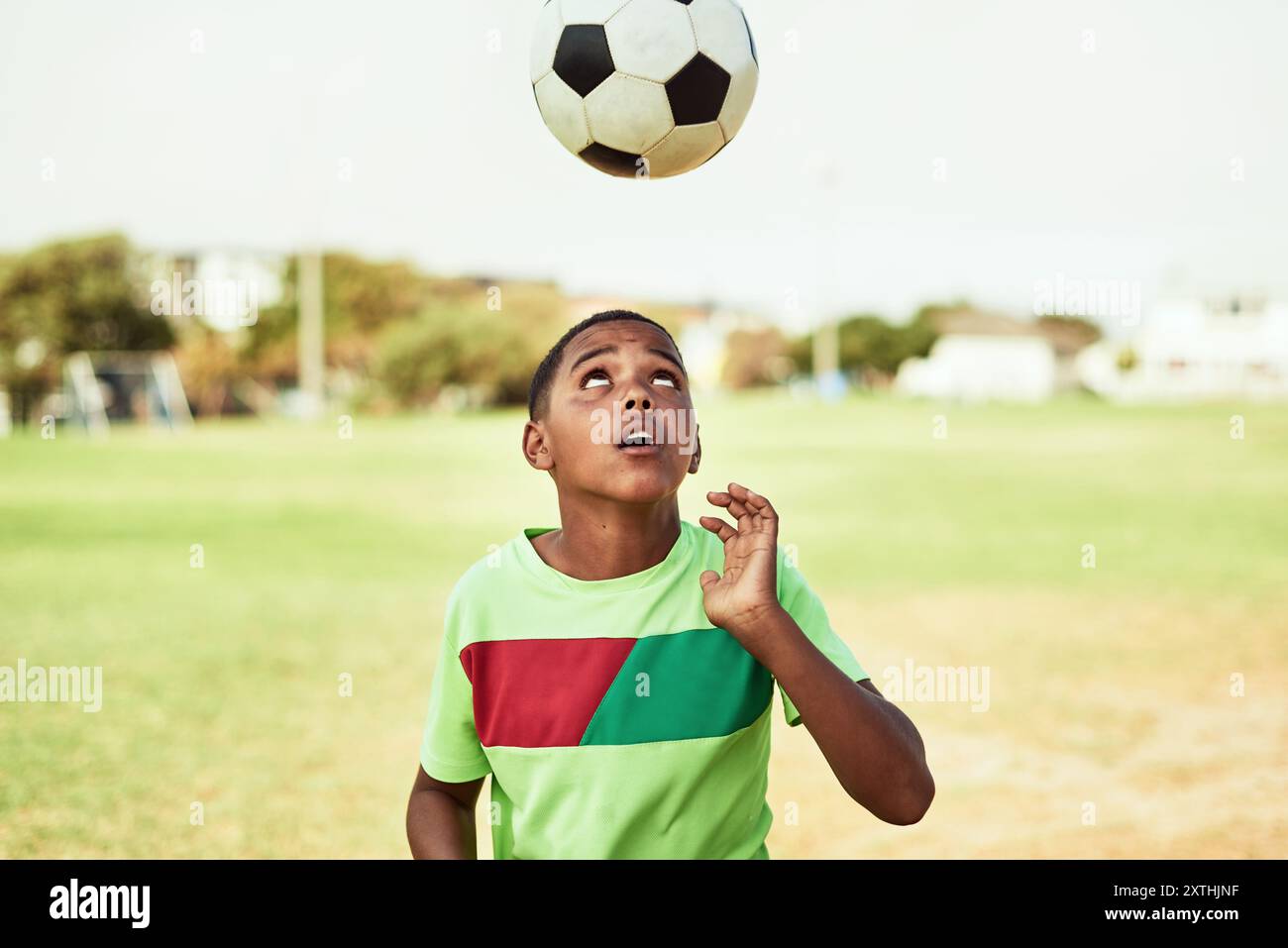 Sport, boy and header ball in football on field for balance, trick ...