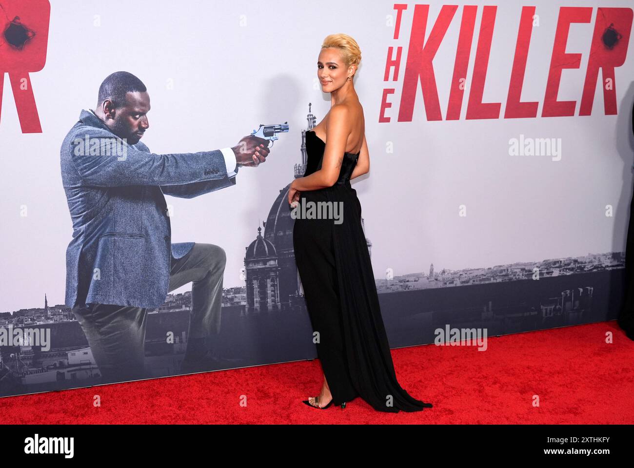 Nathalie Emmanuel, a cast member in "The Killer," poses against key art ...