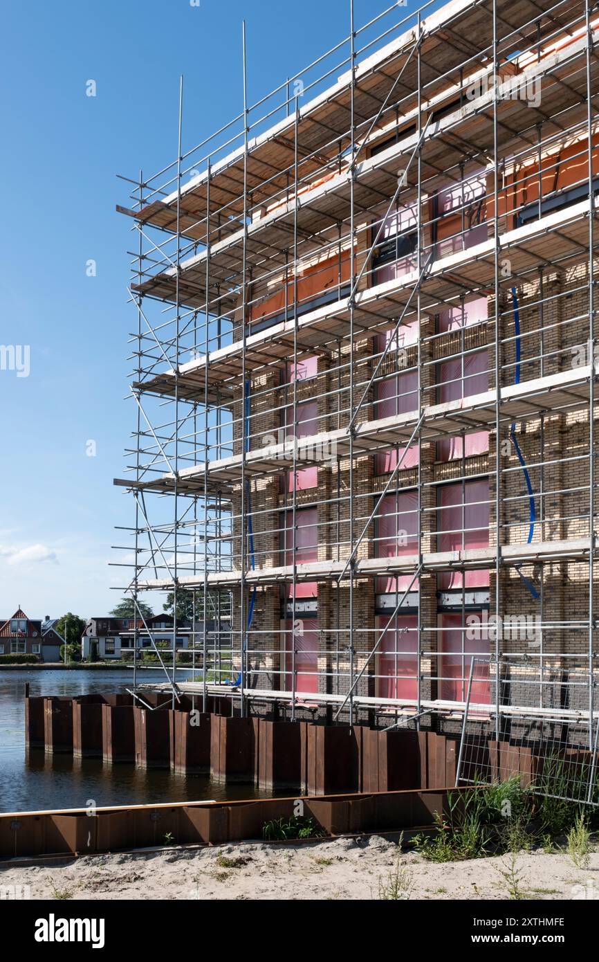 Scaffolding with platforms against a new-build apartment complex on a ...