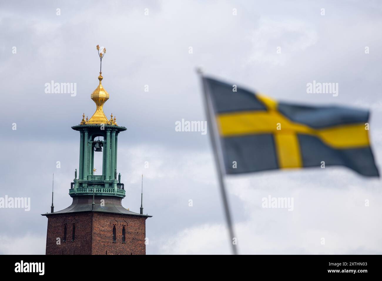 The swedish flag in front of the City hall in the capital of Stockholm ...