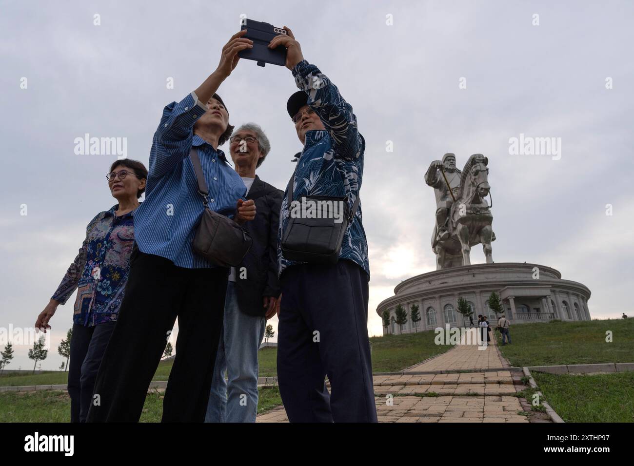 Tourists take photos near the 40-meter- (130-foot-) tall stainless ...