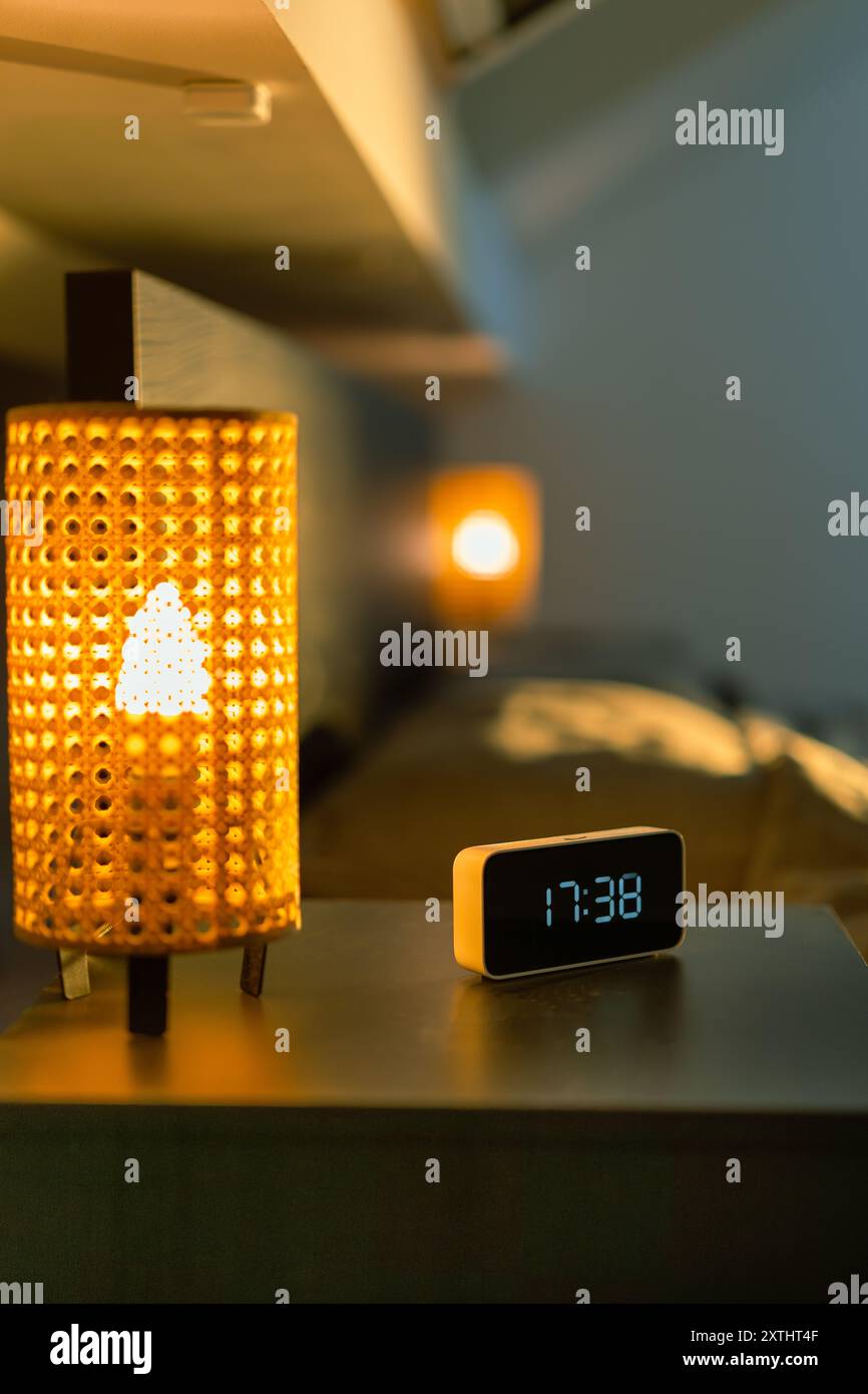 Interior of home bedroom attic. Smart alarm clock on the bedside table ...