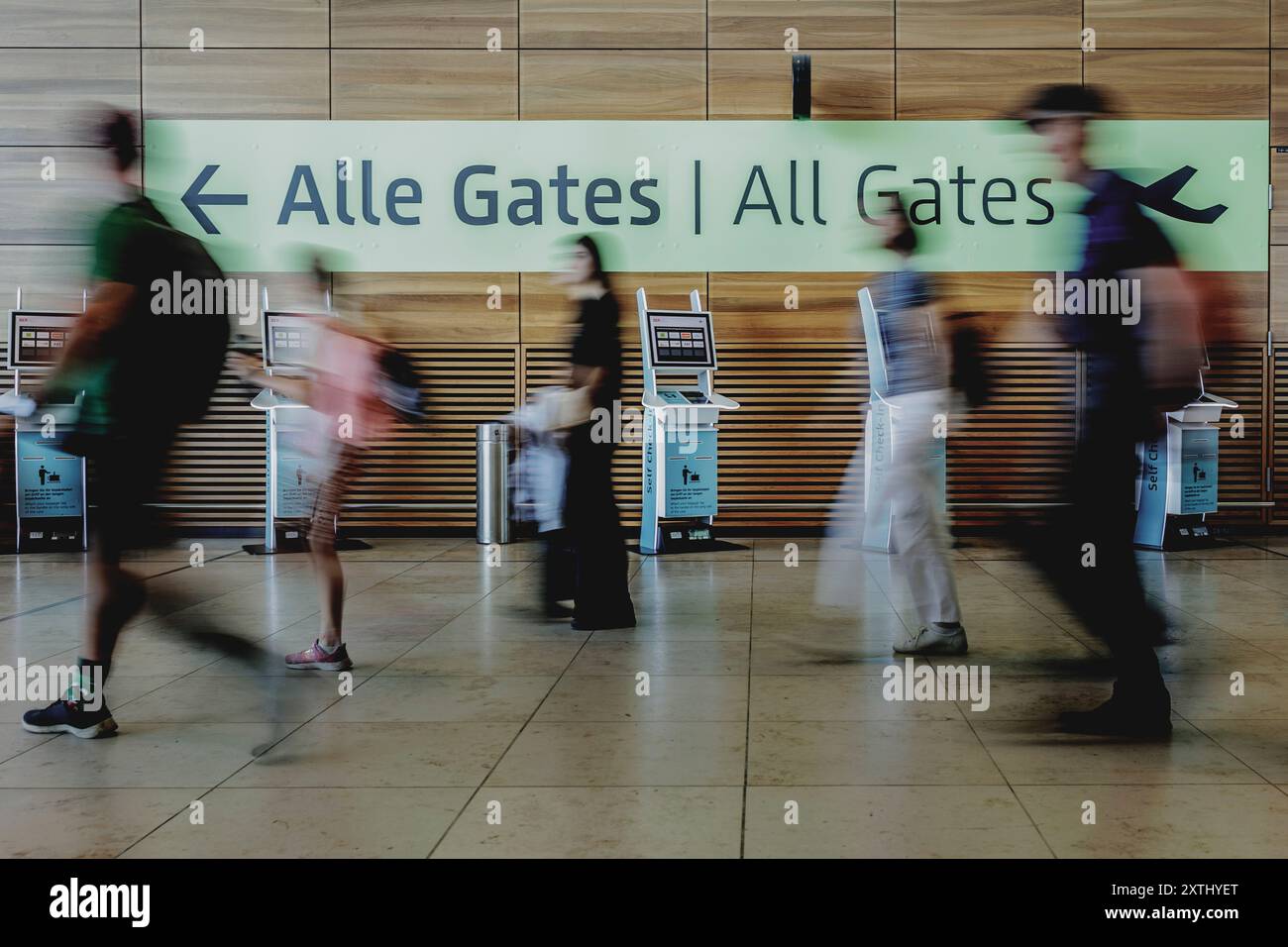 Schoenefeld, Deutschland. 12th Aug, 2024. Travelers line up in front of ...