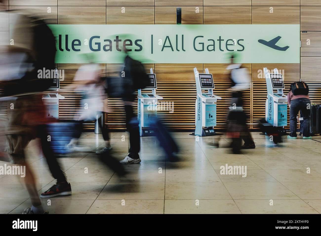 Schoenefeld, Deutschland. 12th Aug, 2024. Travelers line up in front of ...