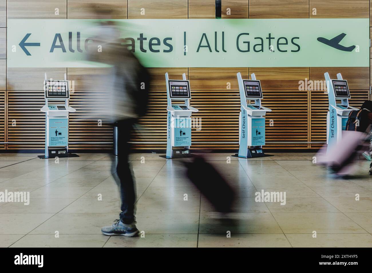 Schoenefeld, Deutschland. 12th Aug, 2024. Travelers line up in front of ...