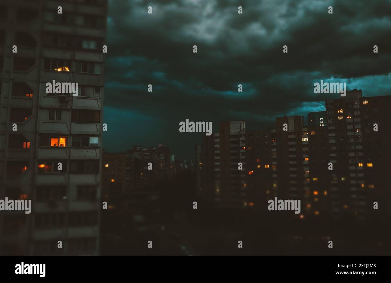 A night city with multi-story apartment buildings under dark blue ...