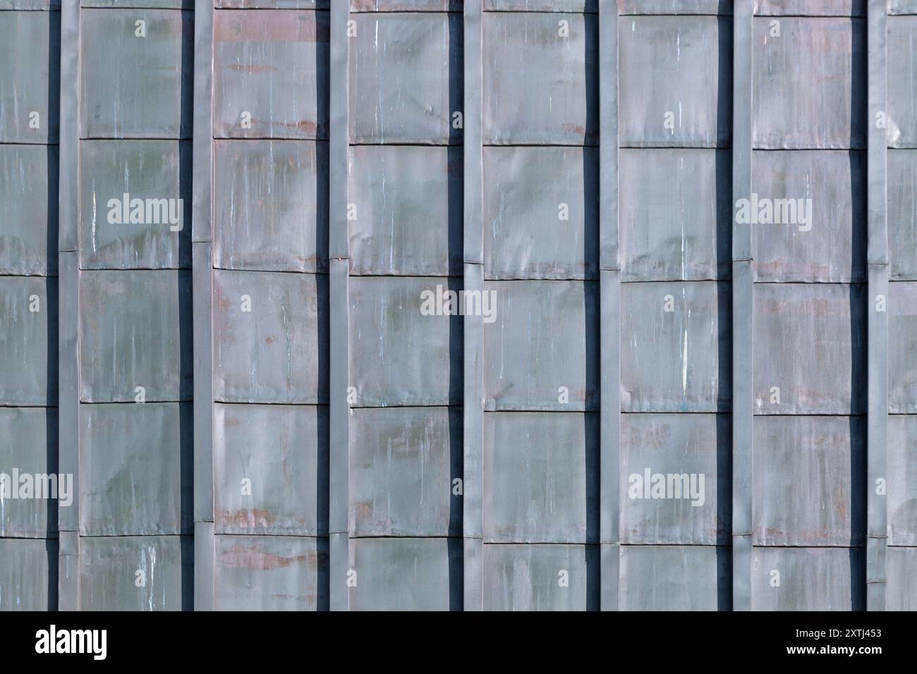 Close-up of weathered metallic wall panels with vertical seams ...