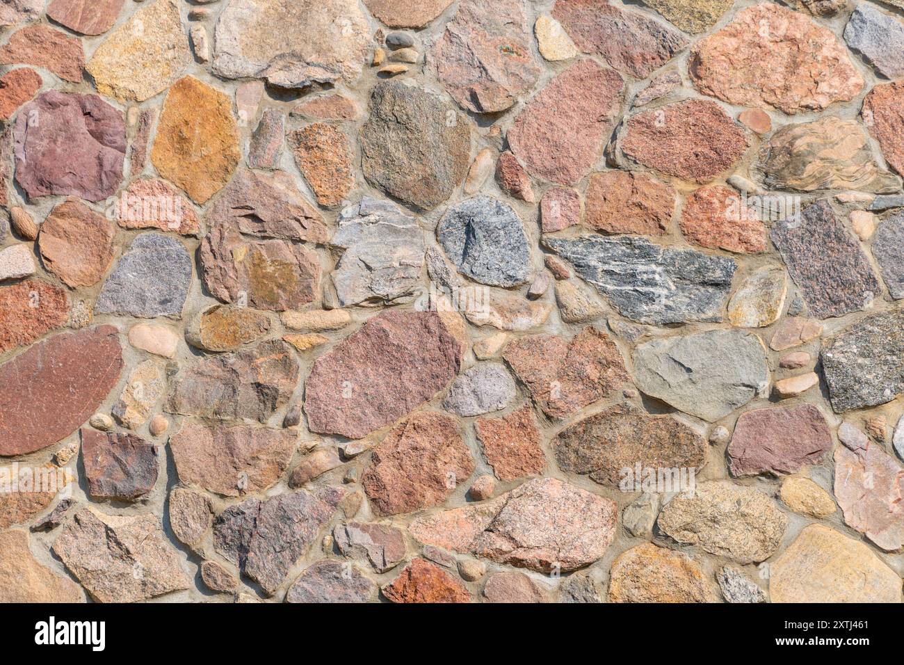 Beautiful stone wall with multi-colored stones. Stone chip. Stone ...