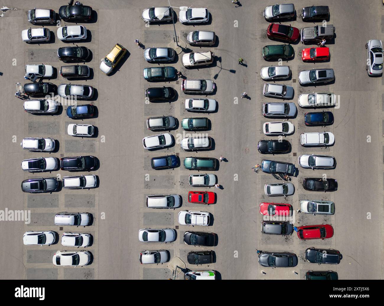 Aerial view of a busy parking lot with neatly arranged cars. The photo ...