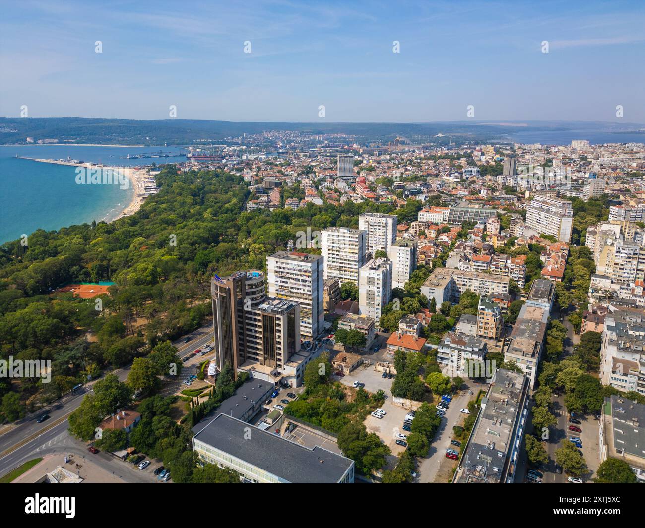 Aerial view of a coastal city with a mix of urban development, lush ...
