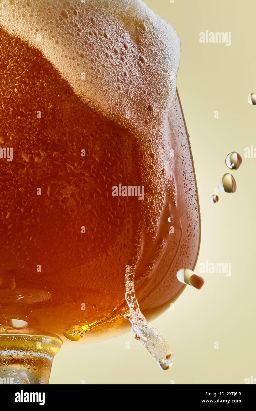 Close up shot of glass in condensation droplets filled with golden ...