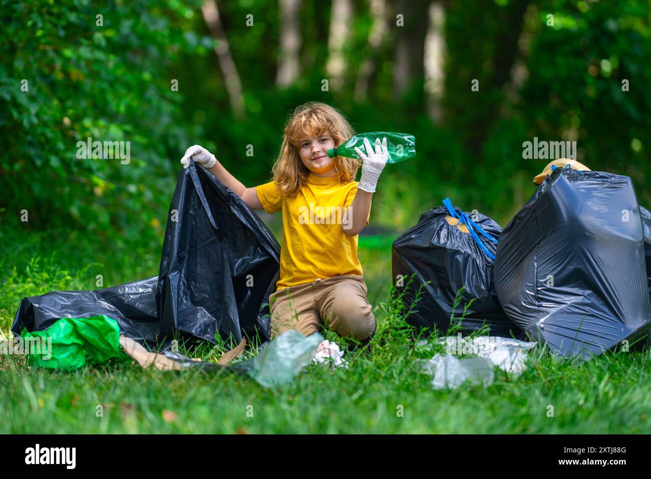Child picking plastic trash for cleaning the nature. kid Clean up ...