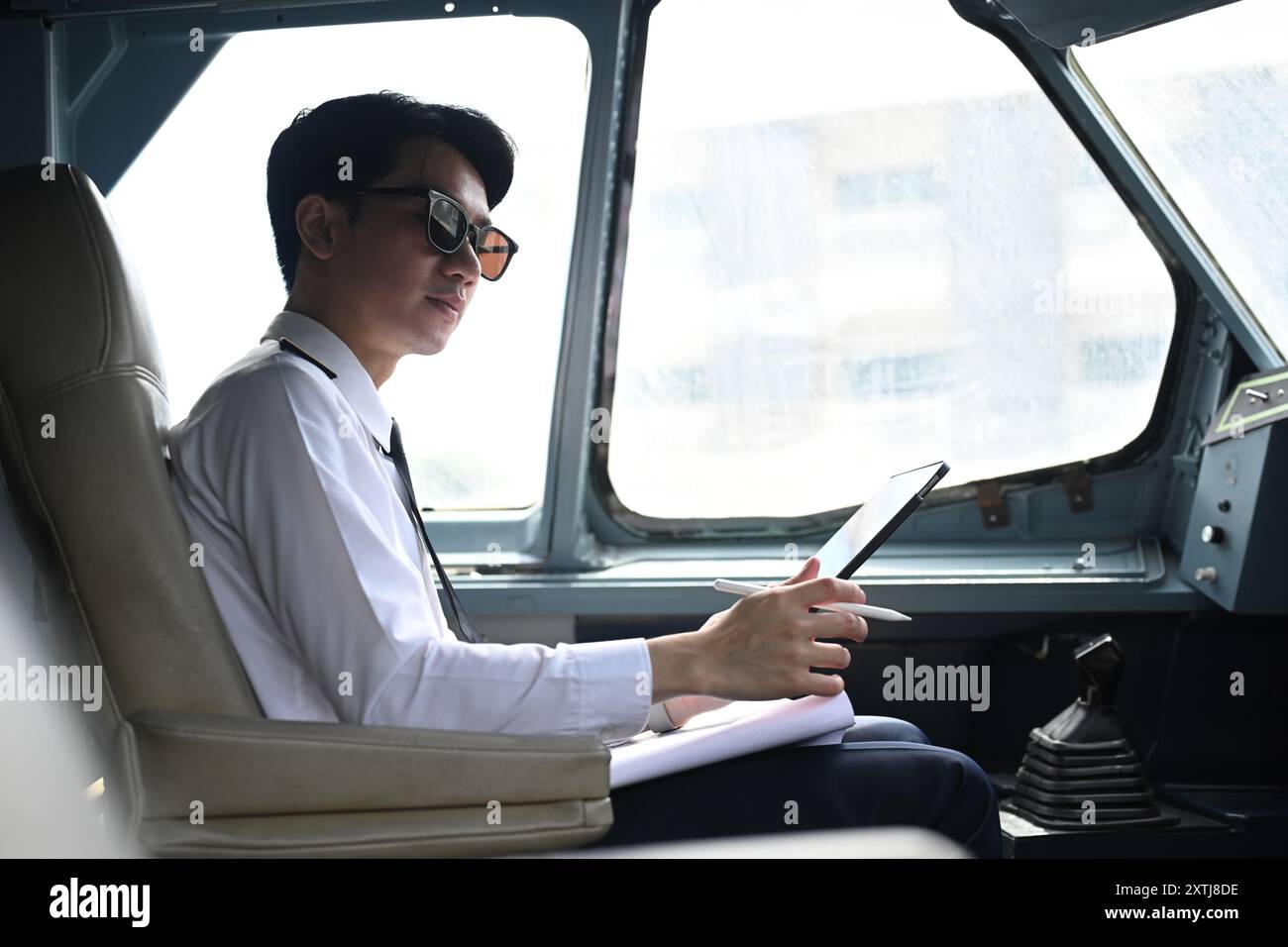 Pilot preparing flight path and check list from digital tablet in the ...