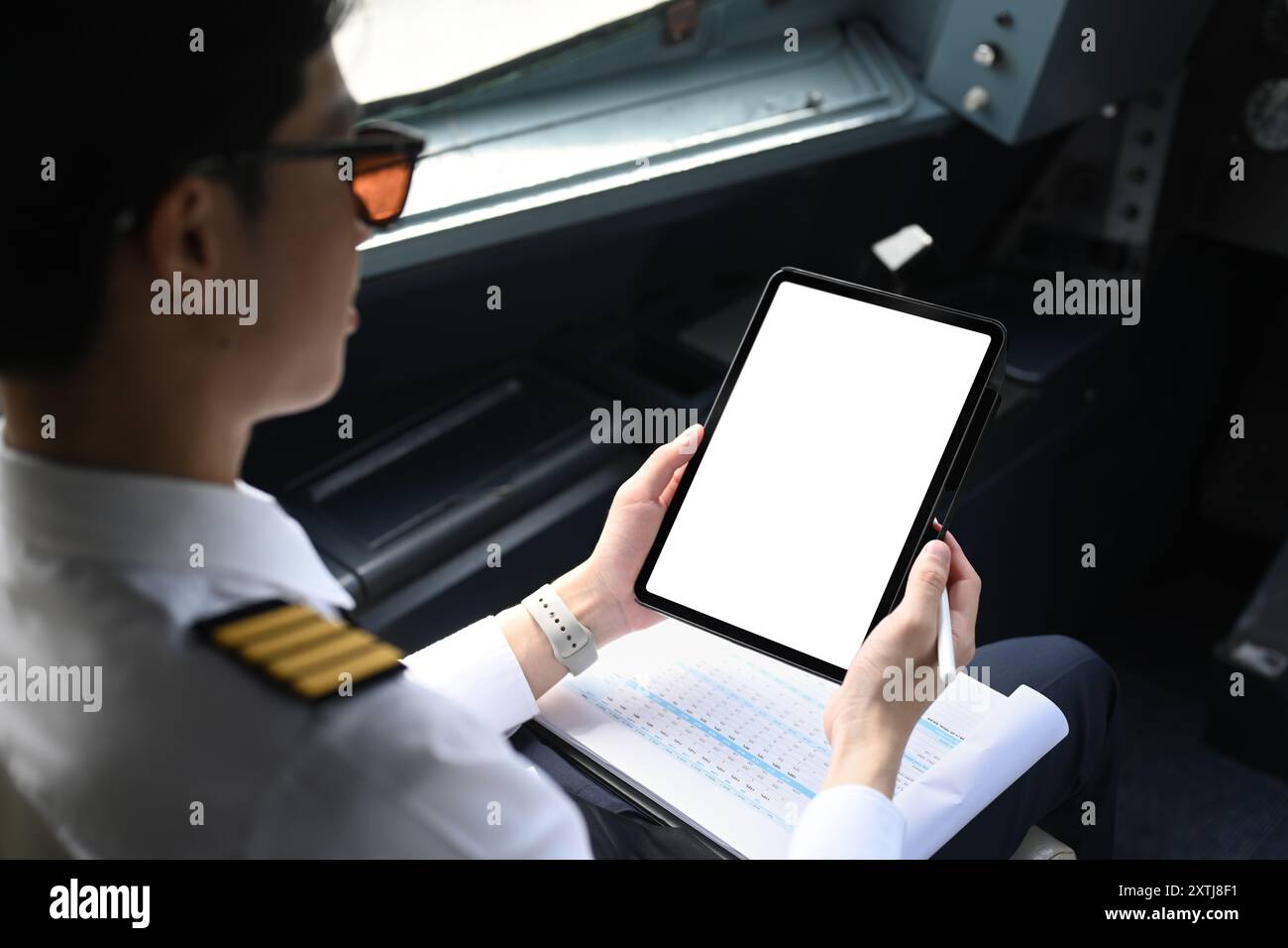 Pilot preparing flight path and check list from digital tablet in the ...