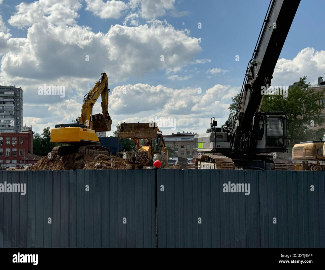 Building destruction, demolition of a building by an yellow excavators ...
