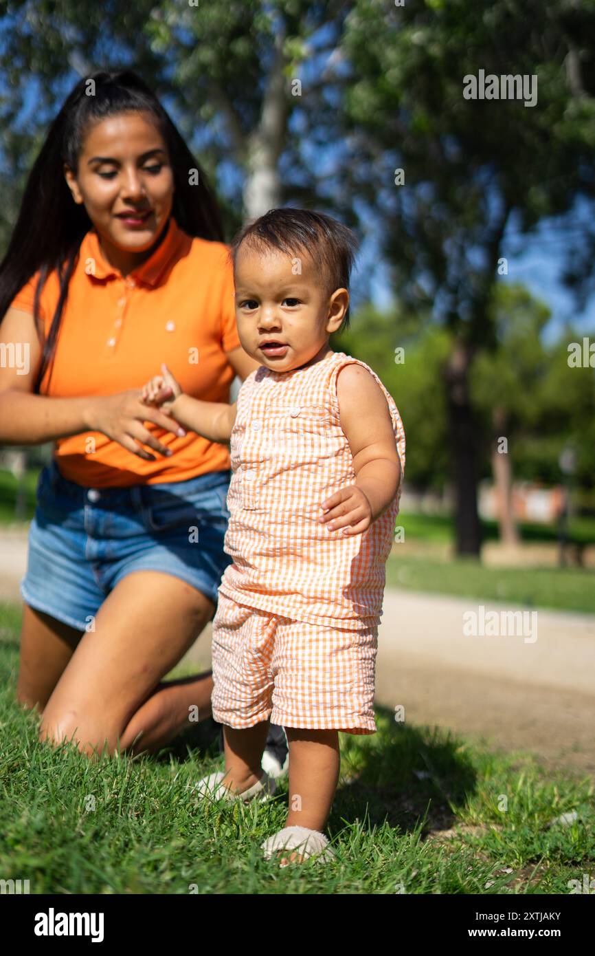 1 year old latin baby girl standing with her young mother outdoors ...