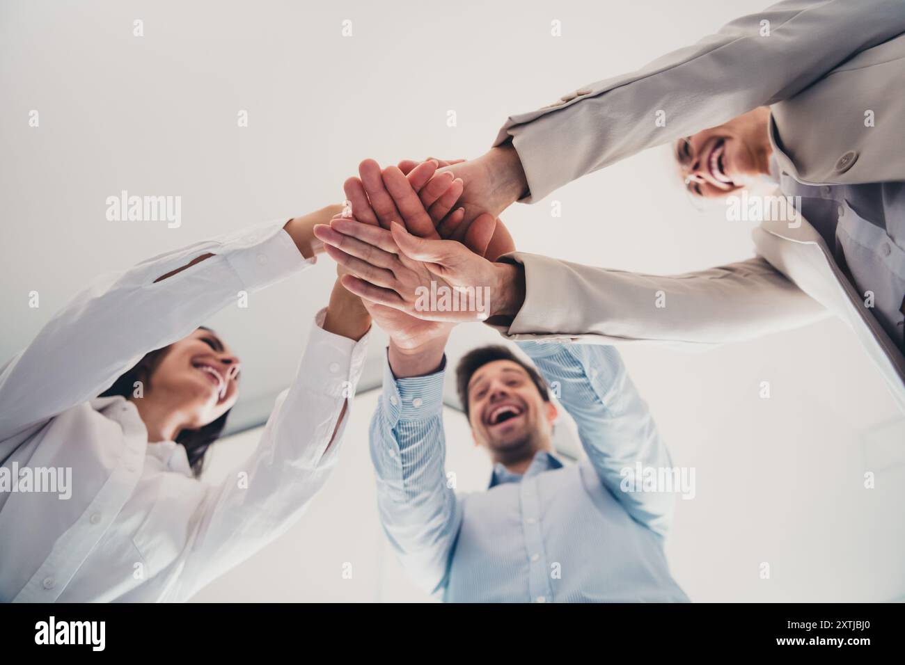 Low angle photo of business people doing team building practice unity ...