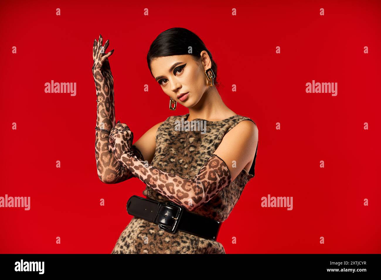Young woman confidently poses in leopard print dress and gloves against ...