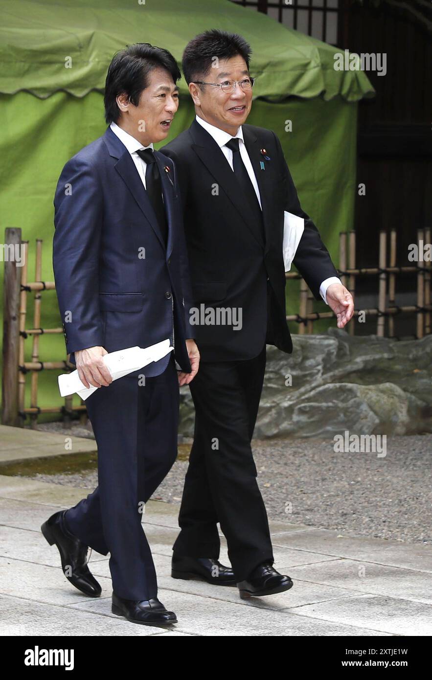 Former Japanese Chief Cabinet Secretary Katsunobu Kato (R) and former ...