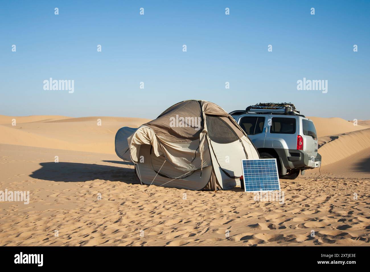Desert camping setup with tent, 4x4 car, and solar panel, with copy ...