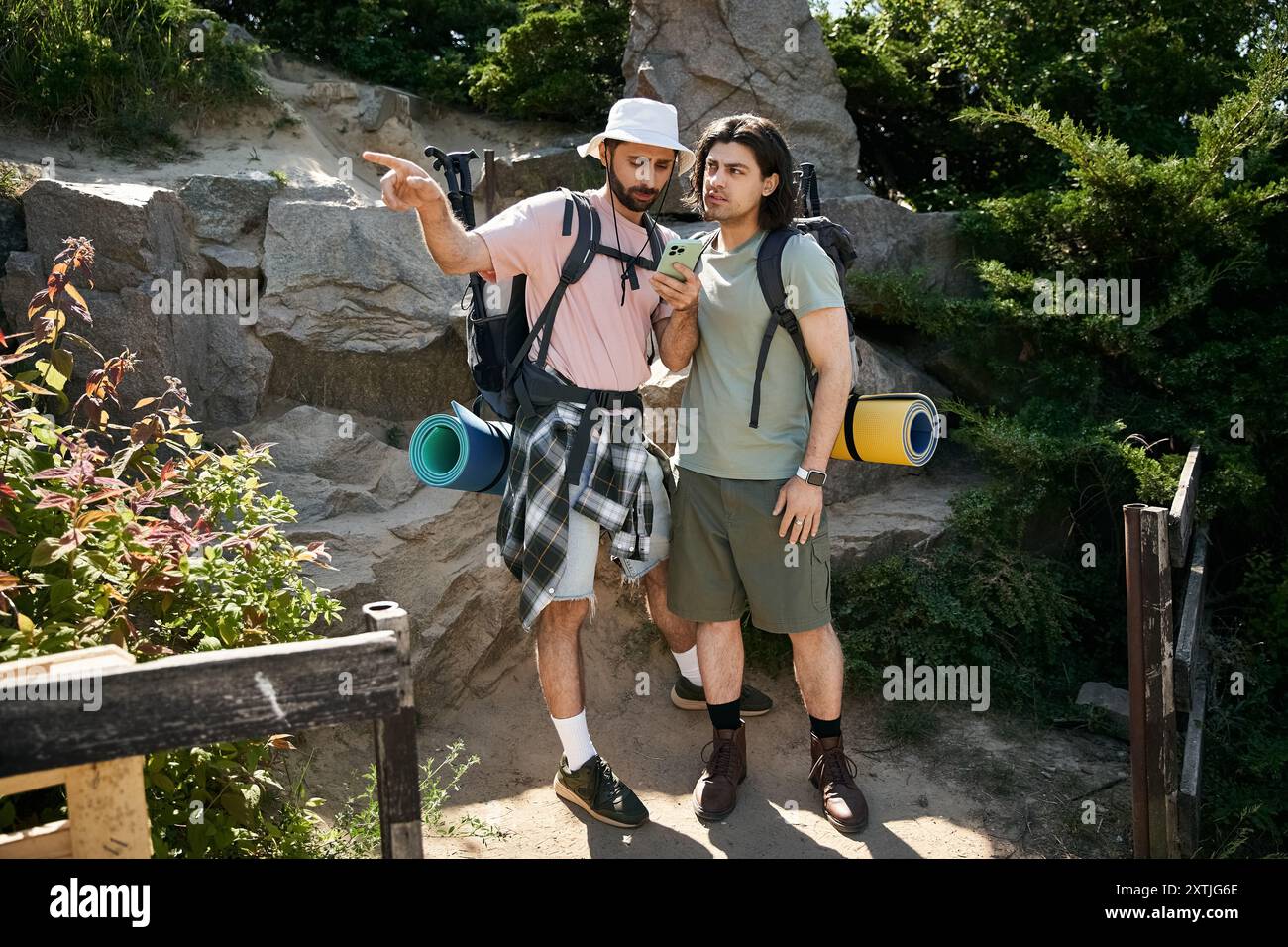 Two young men hiking in the summer wilderness, enjoying a moment of ...