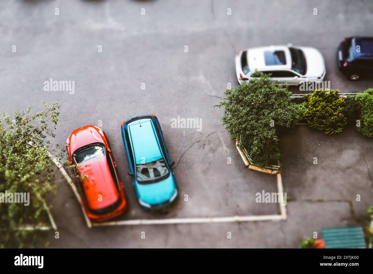 Red and blue cars parked in a parking lot in a residential courtyard ...