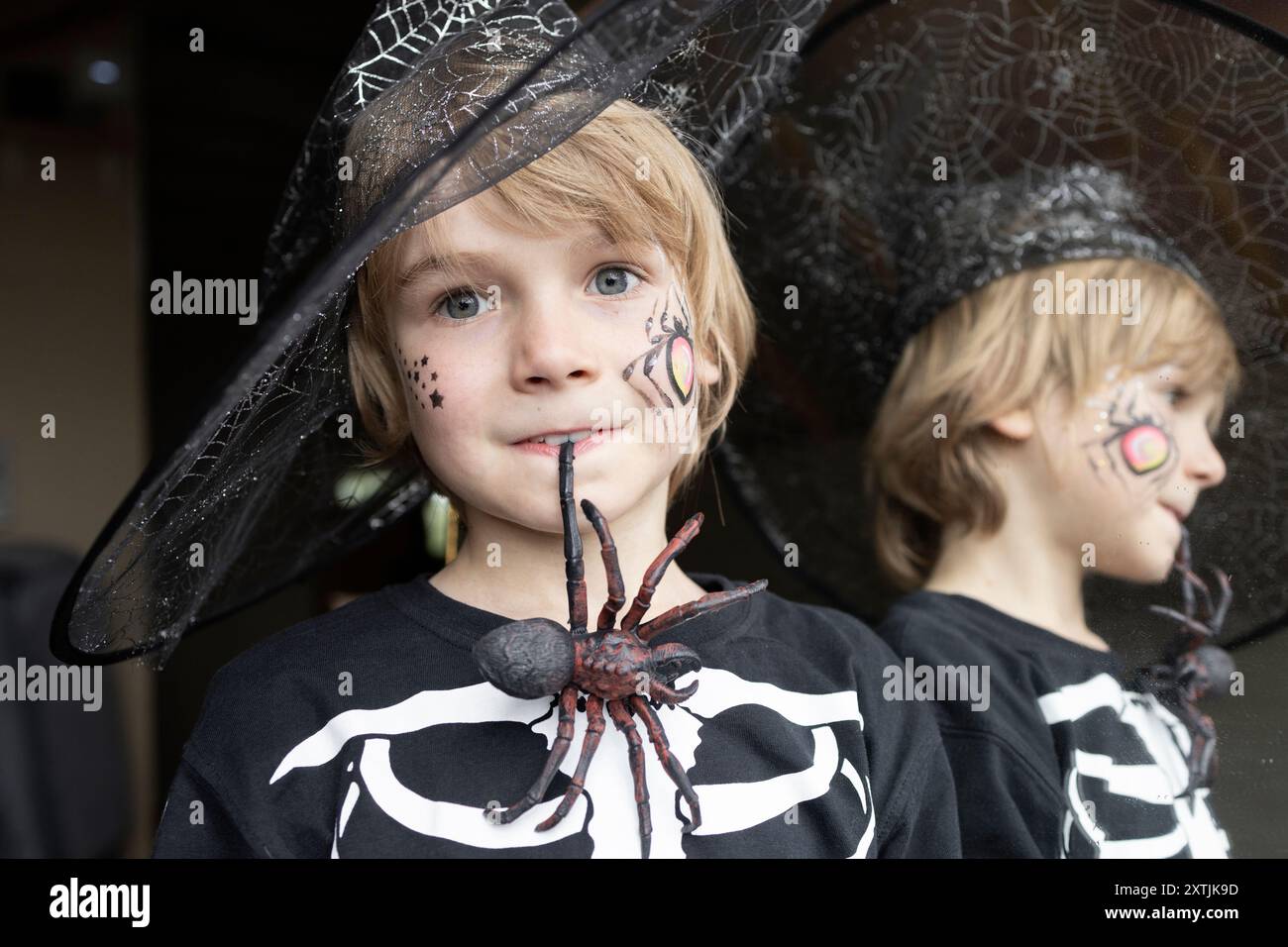 portrait of a boy's face holding a spider in his teeth and reflection ...