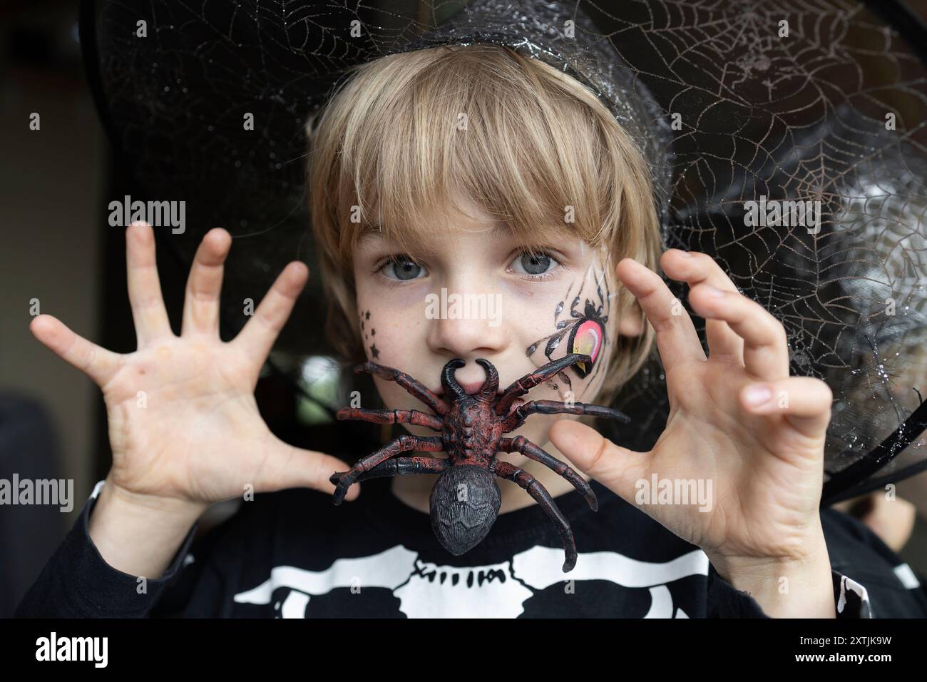 close-up portrait of a boy holding a spider in his teeth with a ...