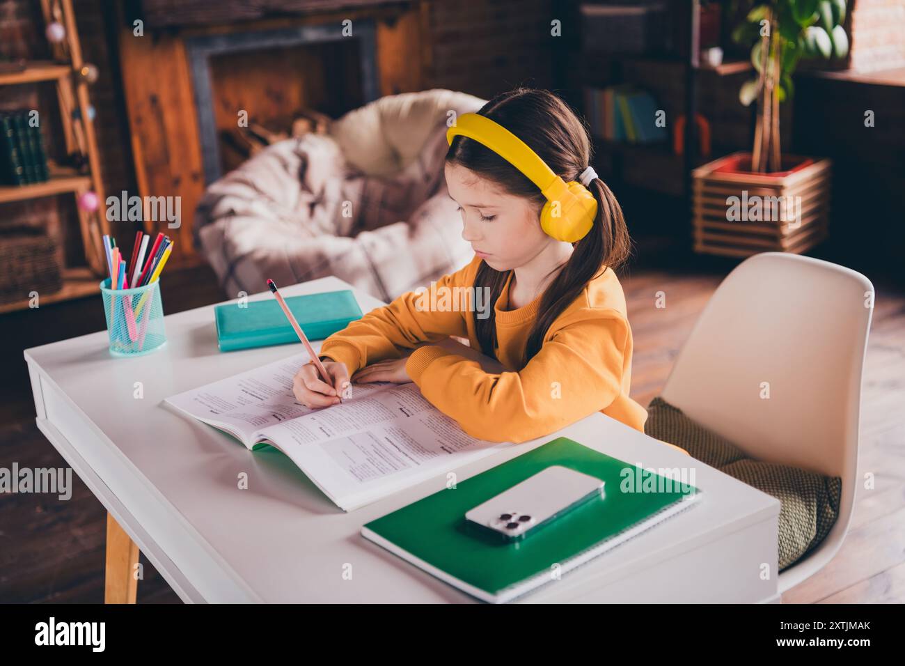 Photo portrait of nice little girl headphones do homework sit table ...