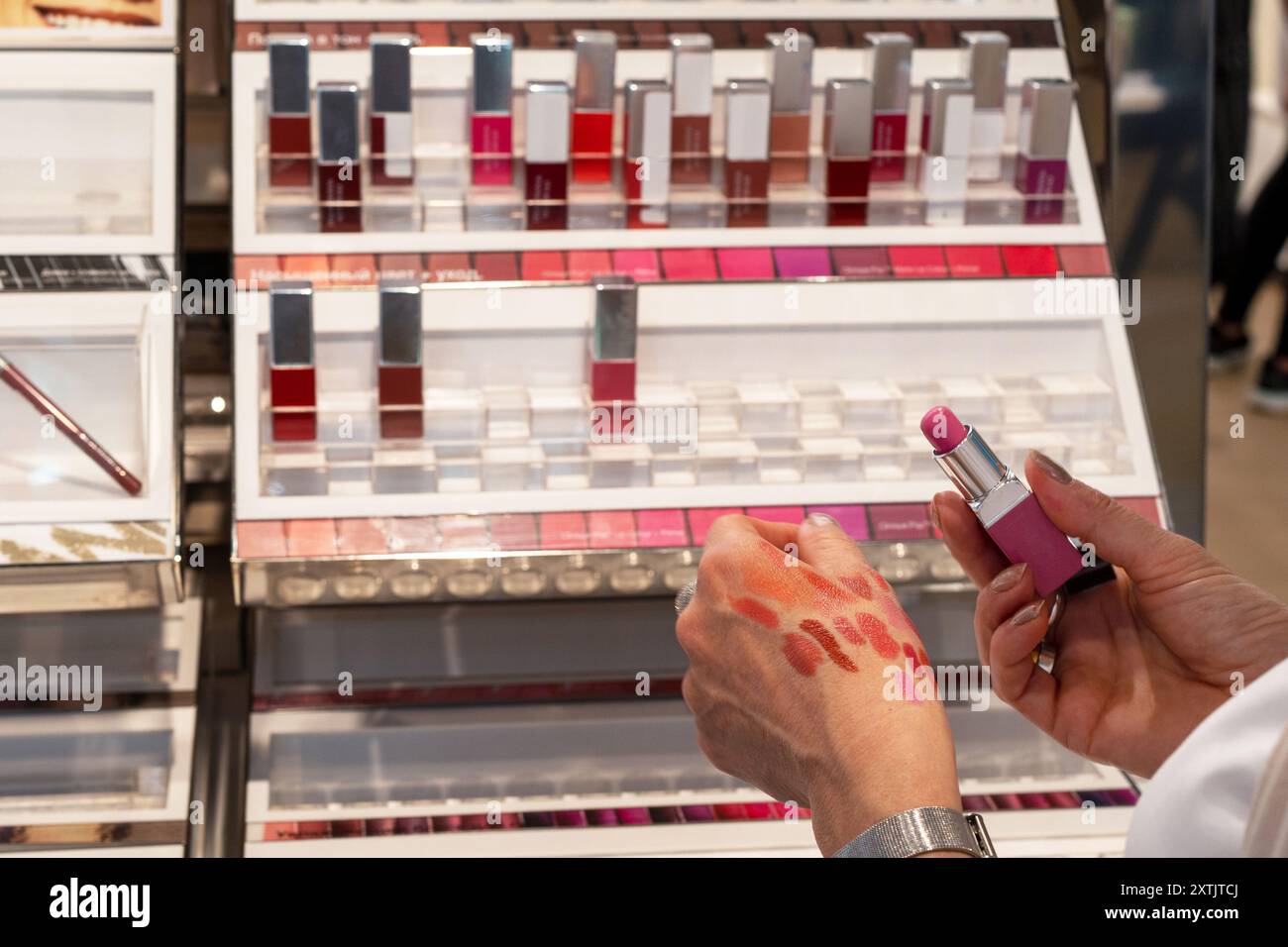 Testing Colorful Cosmetics on Arm. A woman chooses a new lipstick in a ...