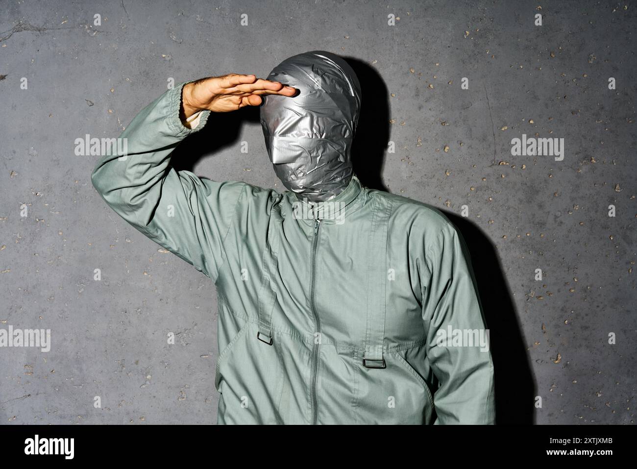 Mystery man with duct tape face looking far away distance over gray ...