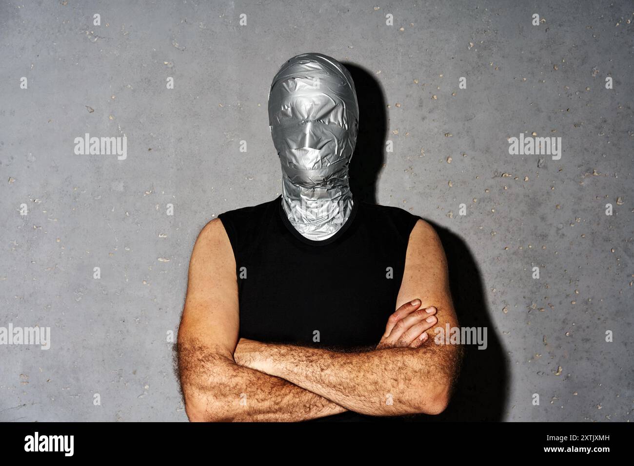 Mystery man with duct tape face wrap with crossed arms on gray ...