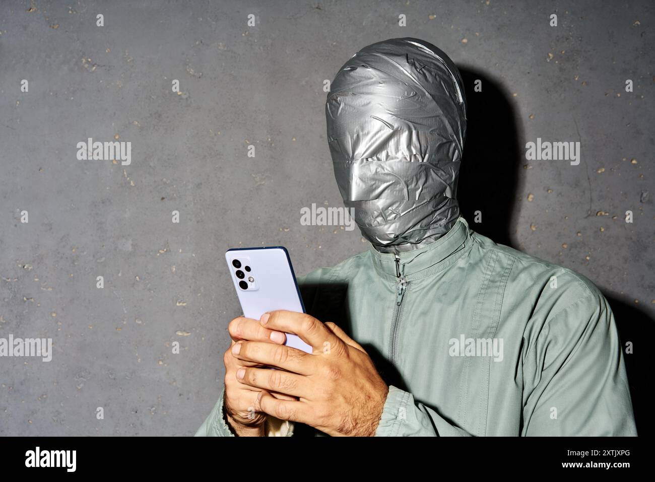 Mystery man with duct tape face types text message on cell phone ...