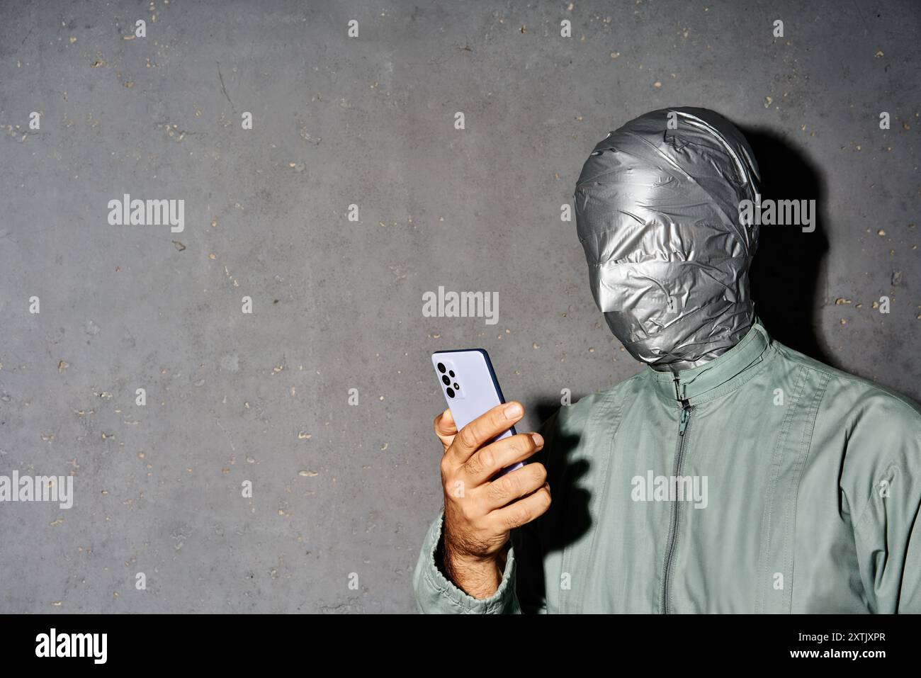 Mystery man with duct tape face types text message on cell phone ...