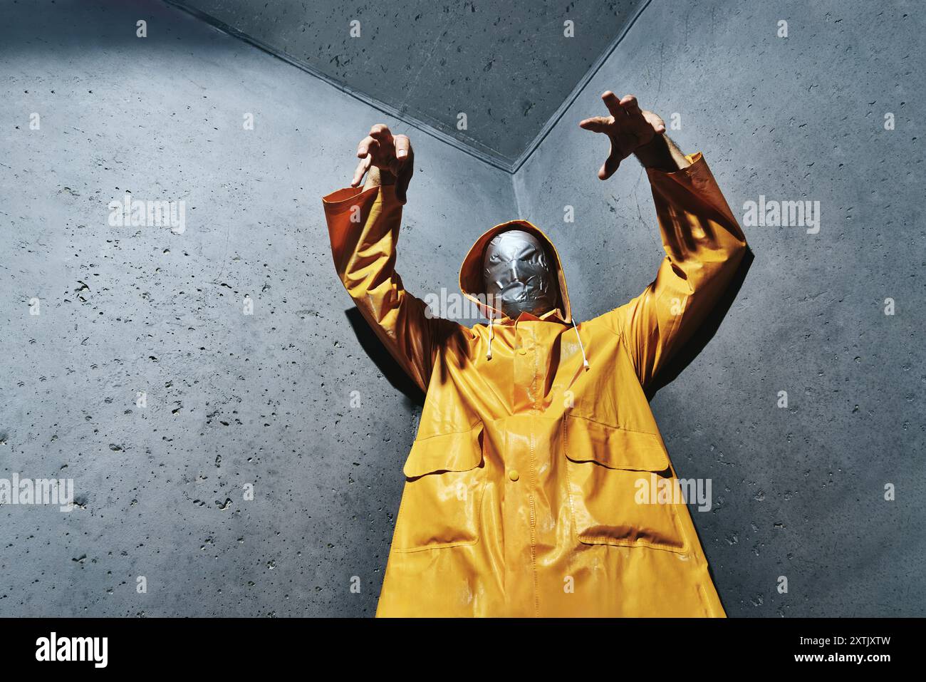 Giant scary man with duct tape face wrap in bright yellow raincoat ...