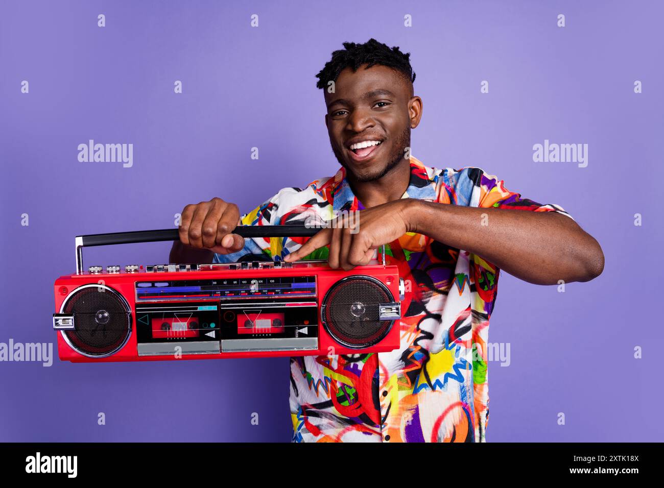 Portrait of nice young man press play button boombox isolated on purple ...