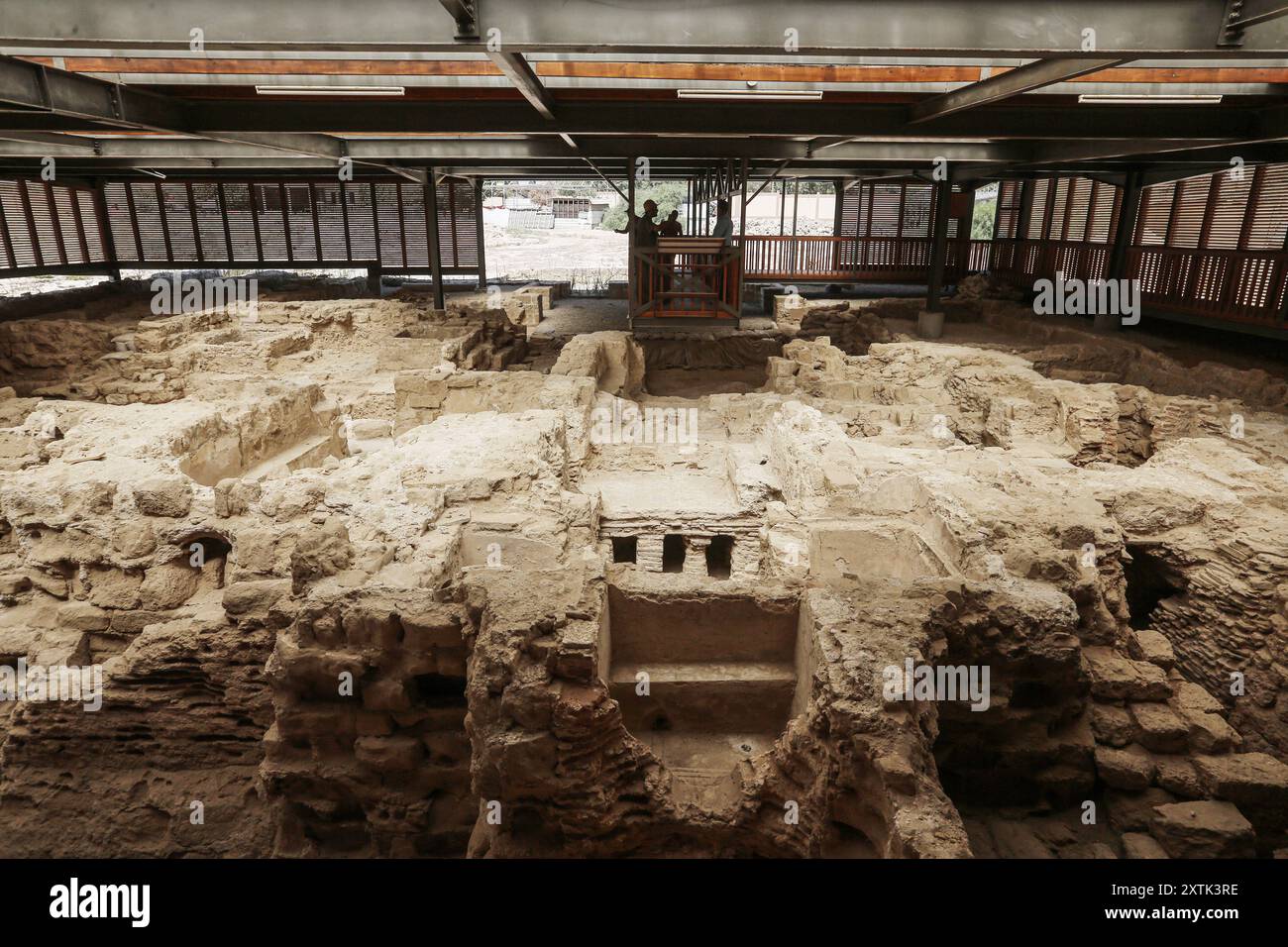 People stand on a platform overlooking ruins at the archaeological site ...