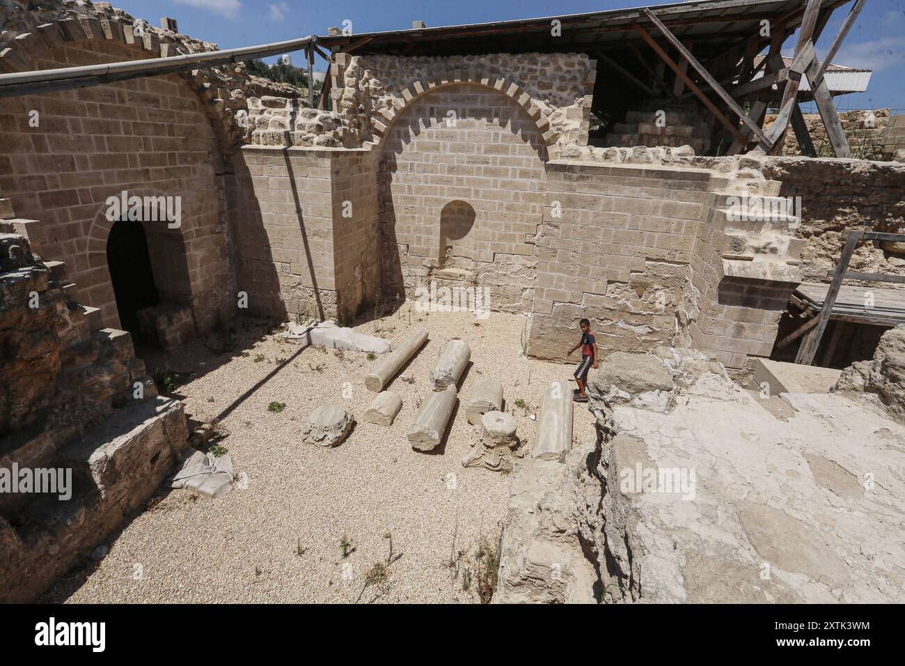 People stand on a platform overlooking ruins at the archaeological site ...