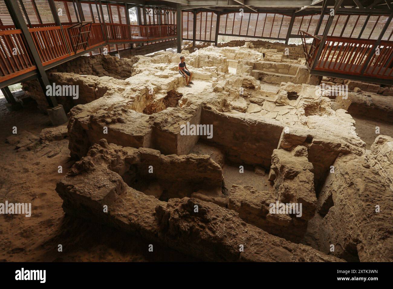 People stand on a platform overlooking ruins at the archaeological site ...