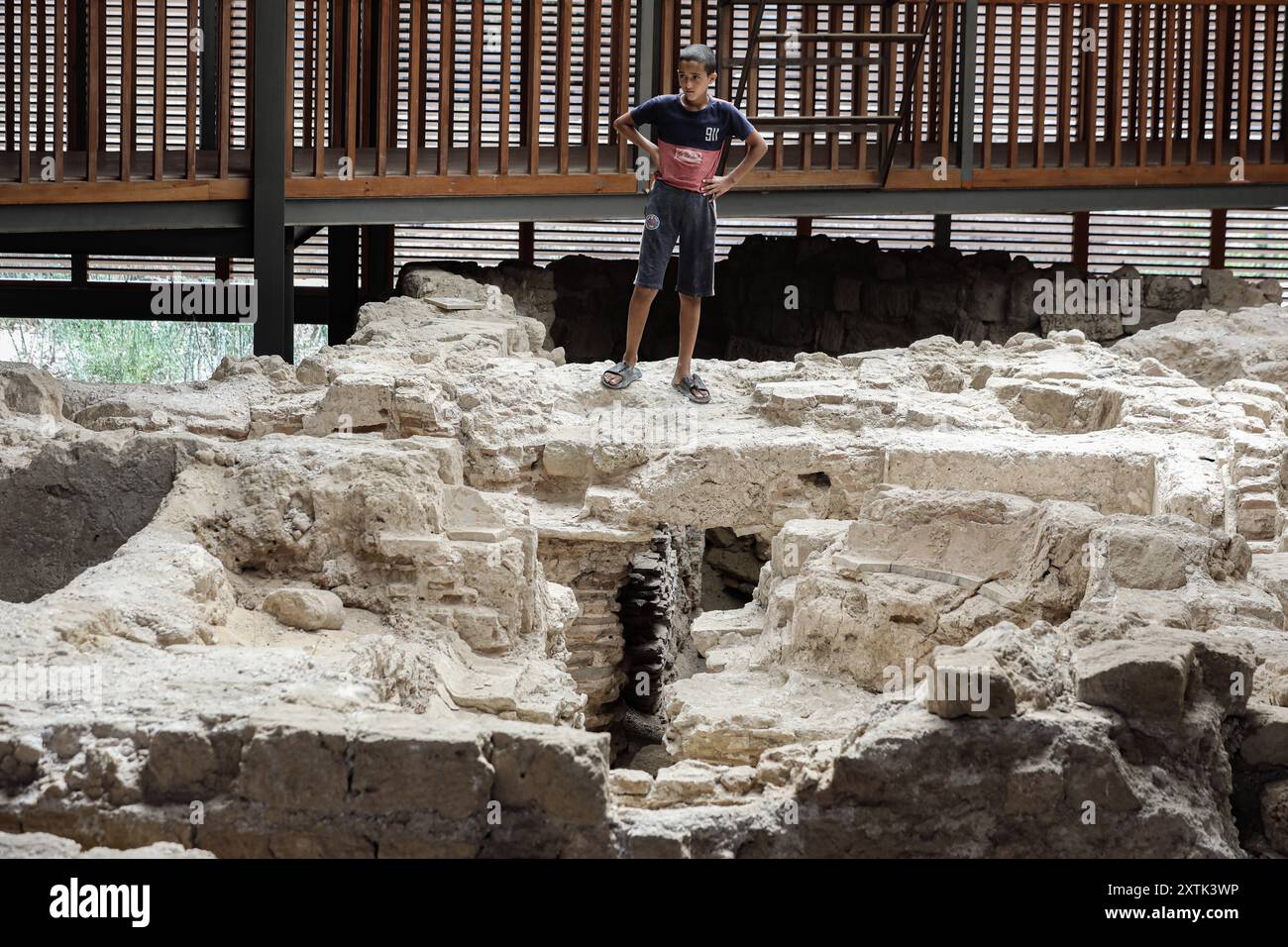 People stand on a platform overlooking ruins at the archaeological site ...