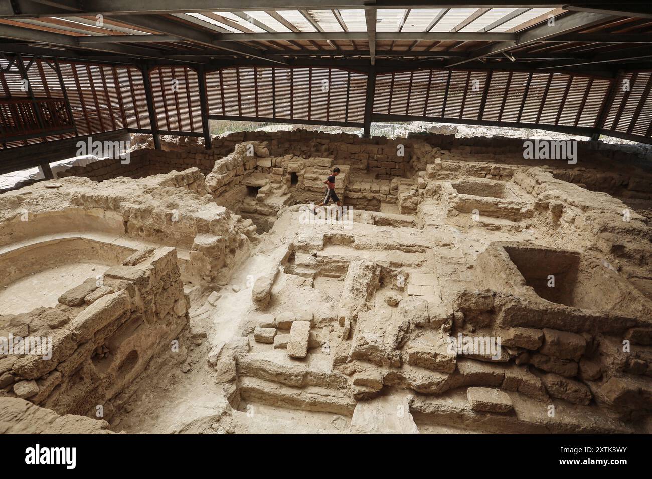 People stand on a platform overlooking ruins at the archaeological site ...