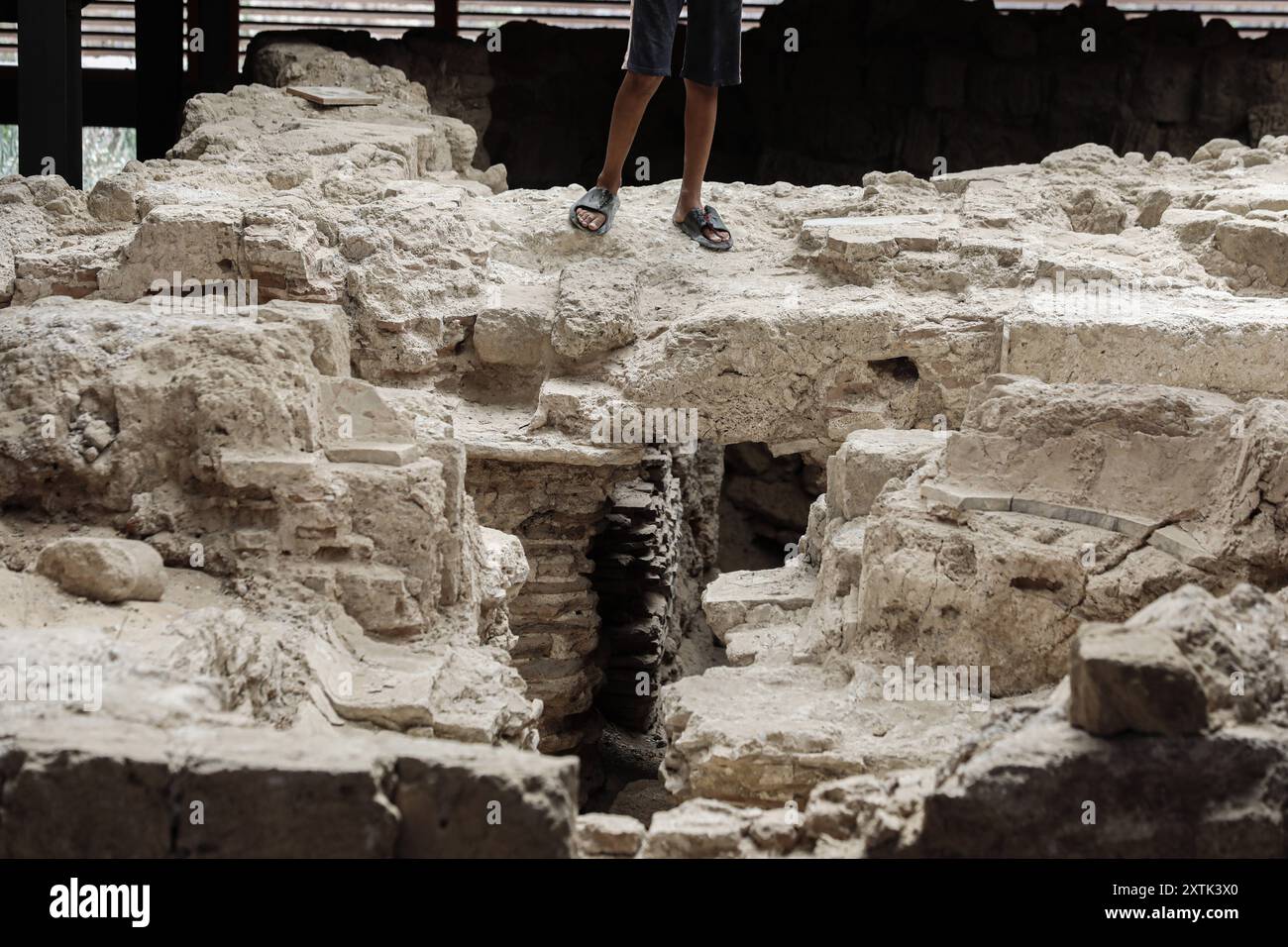 People stand on a platform overlooking ruins at the archaeological site ...