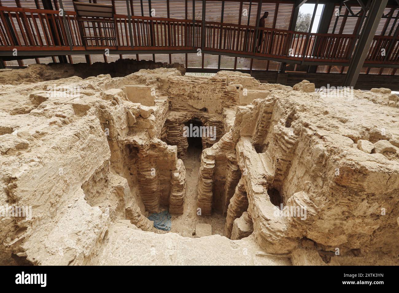 People stand on a platform overlooking ruins at the archaeological site ...
